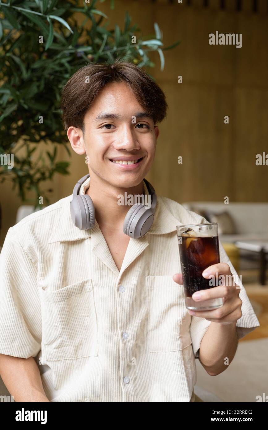Non binary cute Asian student man sitting in modern coffee shop Stock ...