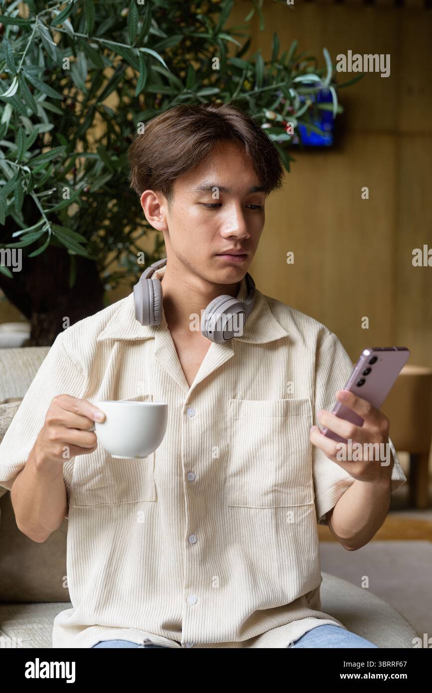 Non binary cute Asian student man sitting in modern coffee shop Stock ...
