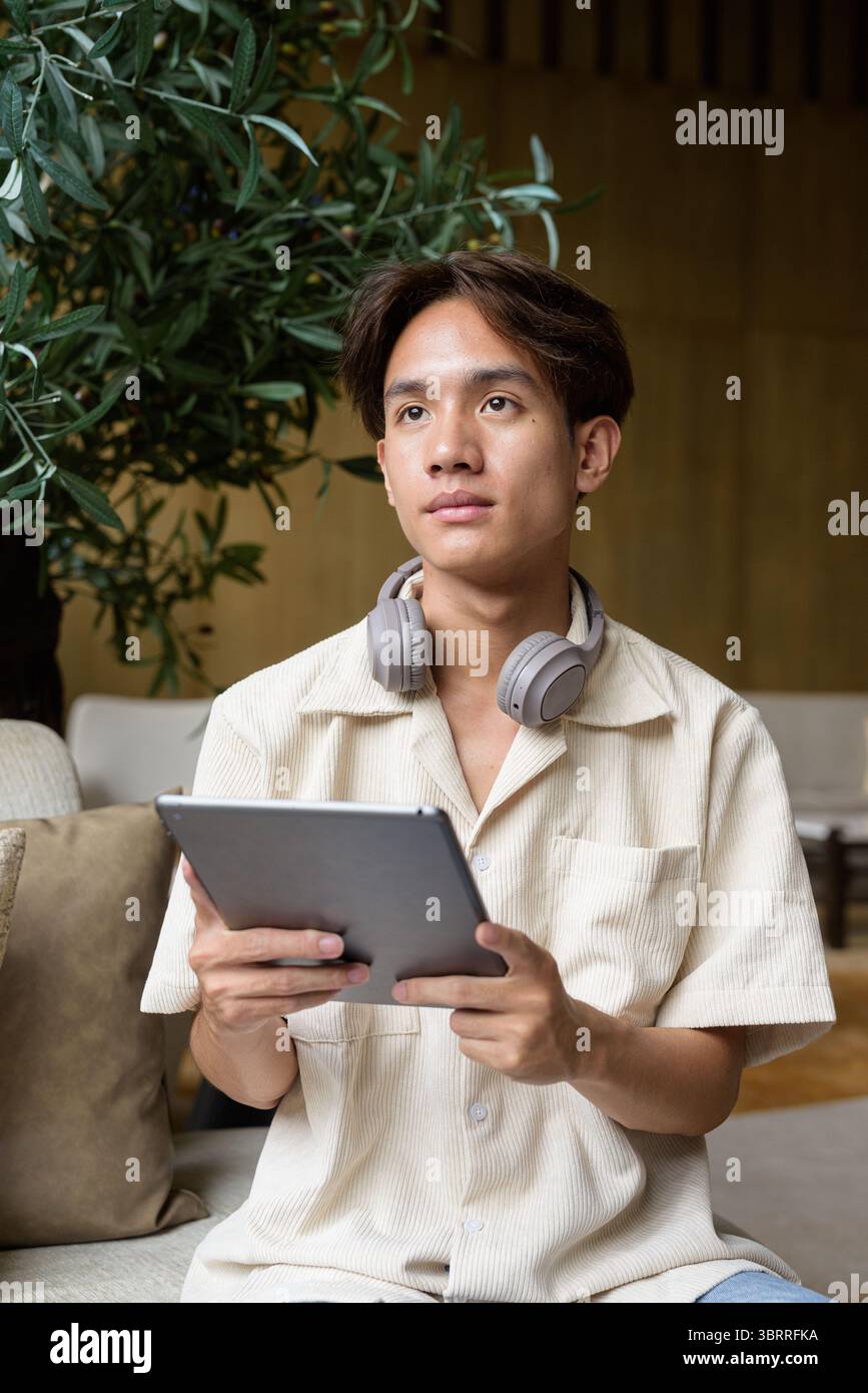 Non binary cute Asian student man sitting in modern coffee shop Stock ...