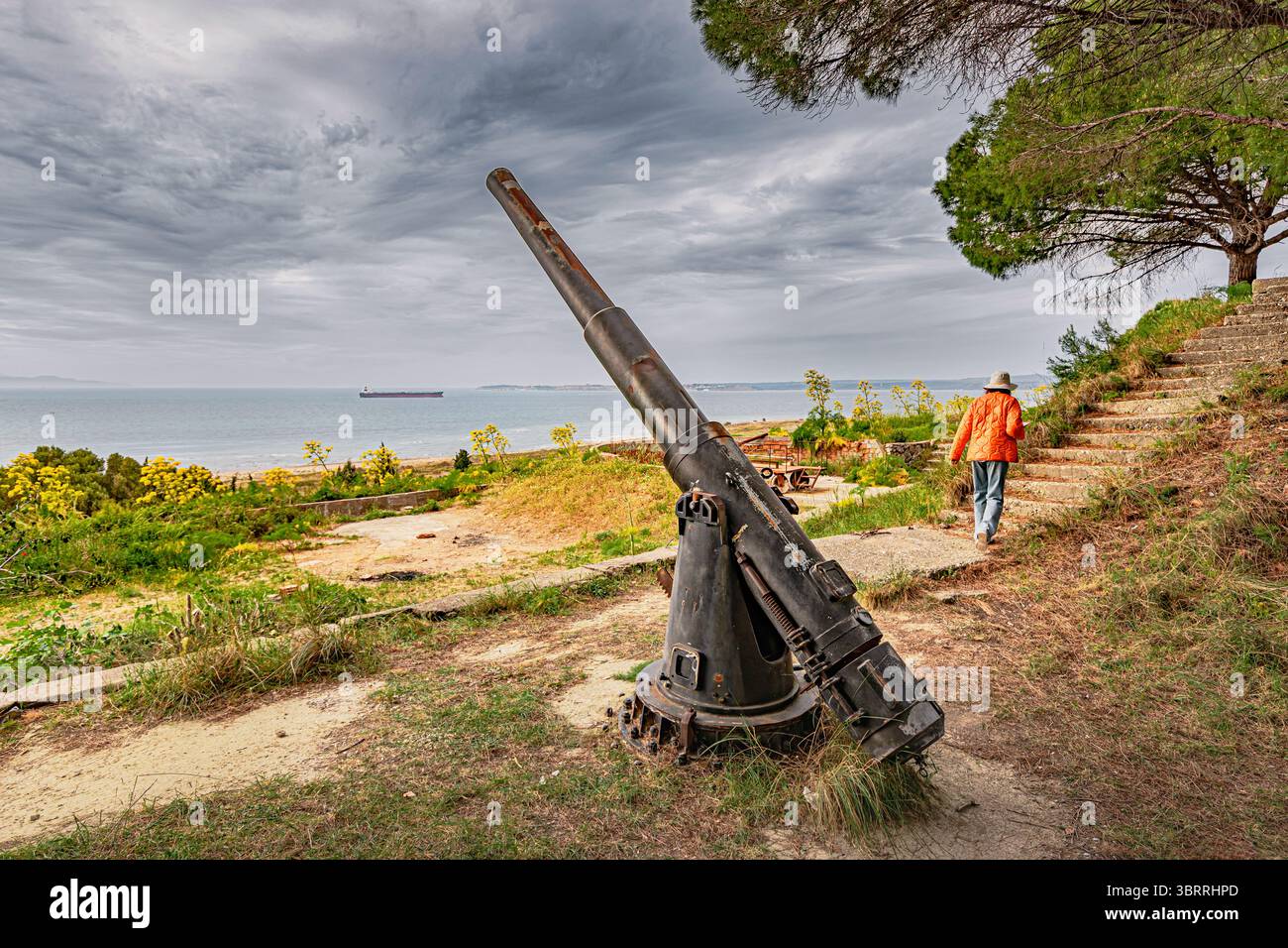 Tourist pointing at an old Turkish military cannon overlooking the ...