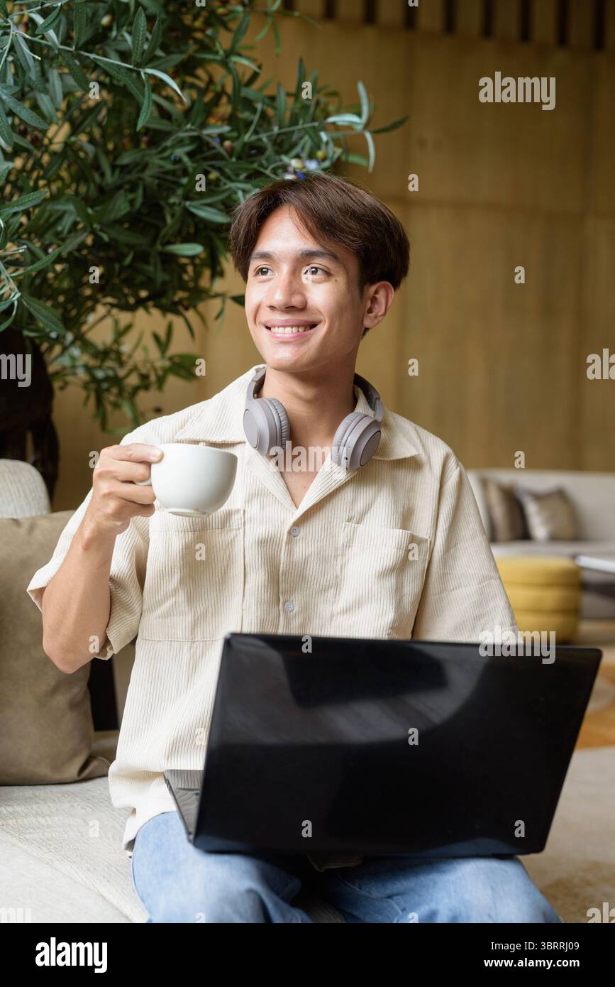 Non binary cute Asian student man sitting in modern coffee shop Stock ...