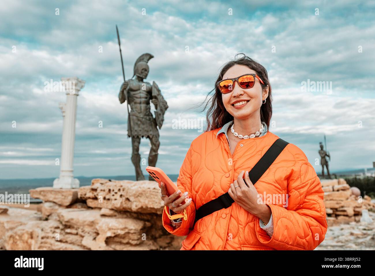 05 May 2025, Uluova, Turkiye: Woman tourist with smartphone near Iliad ...