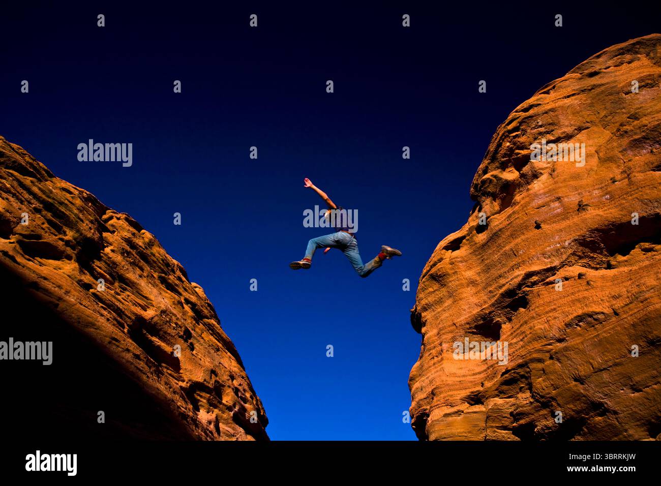 A man jumps across a chasm while hiking in Grand Staircase-Escalante ...