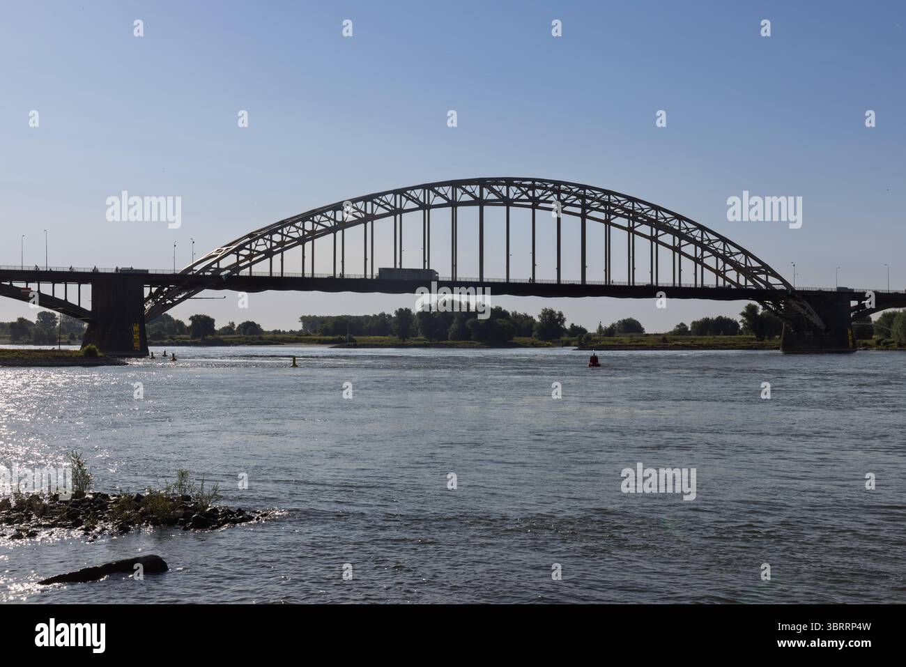 The iconic Waalbrug, a historic arch bridge, spans the Waal River in ...