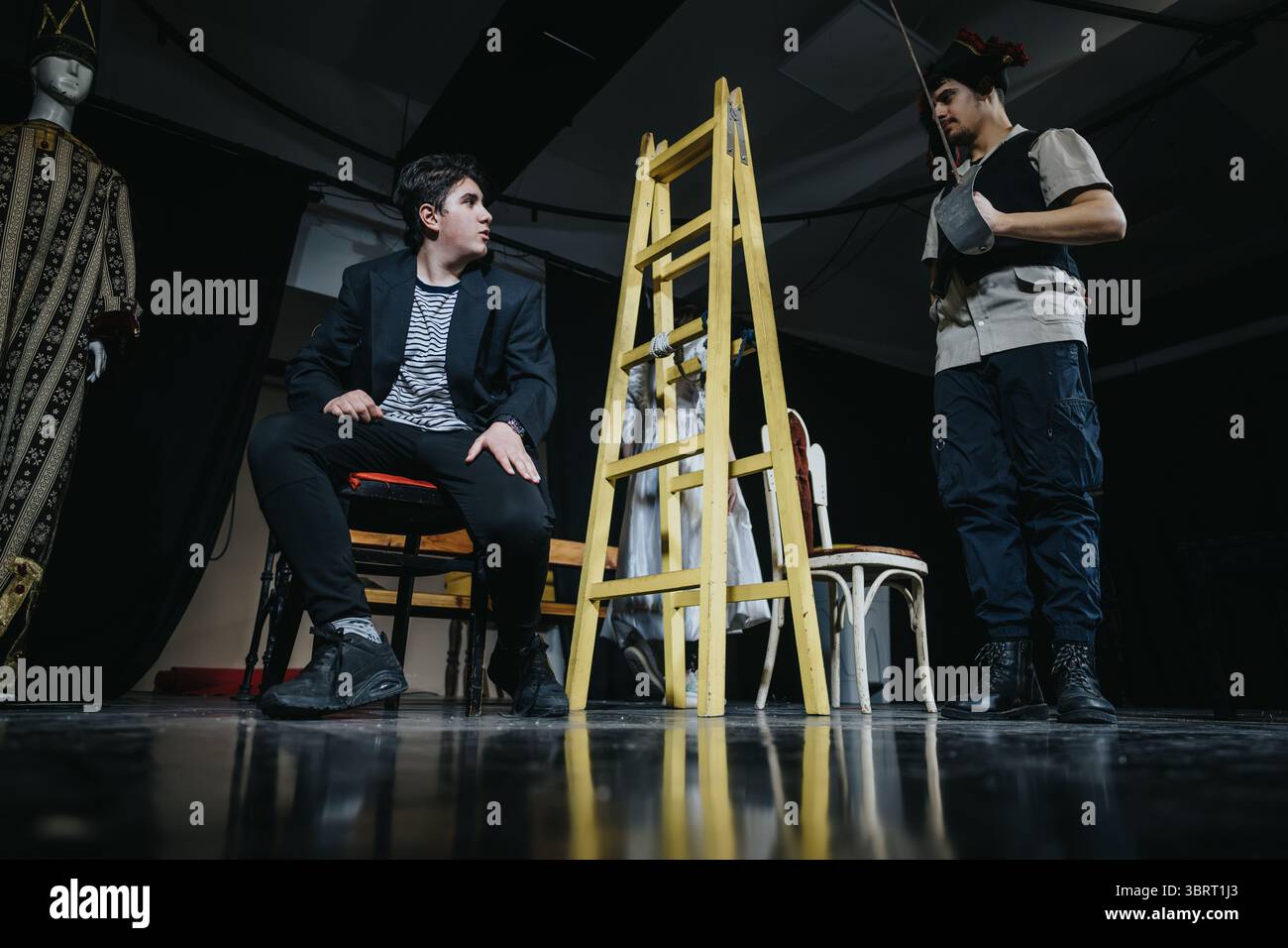 Young actors rehearsing in a theatrical setting, with dramatic stage ...