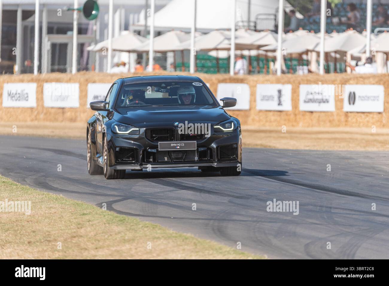 2025 BMW M2 CS car driving up the hill climb track at the Goodwood ...