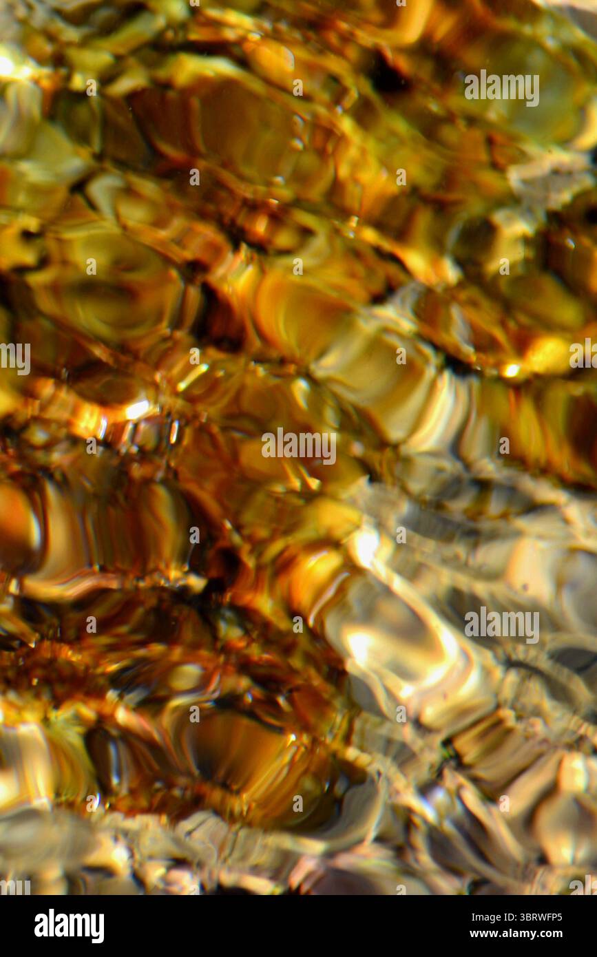 The light distorted by refraction and reflection on moving water ...