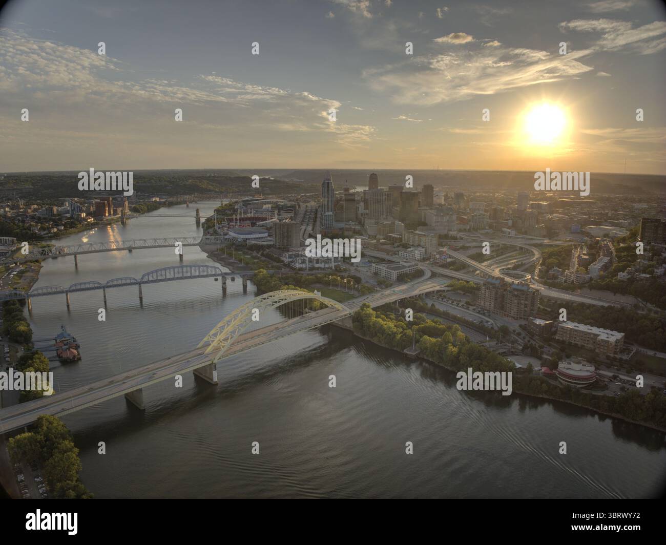 Aerial view of the sun setting over the city skyline, with bridges ...