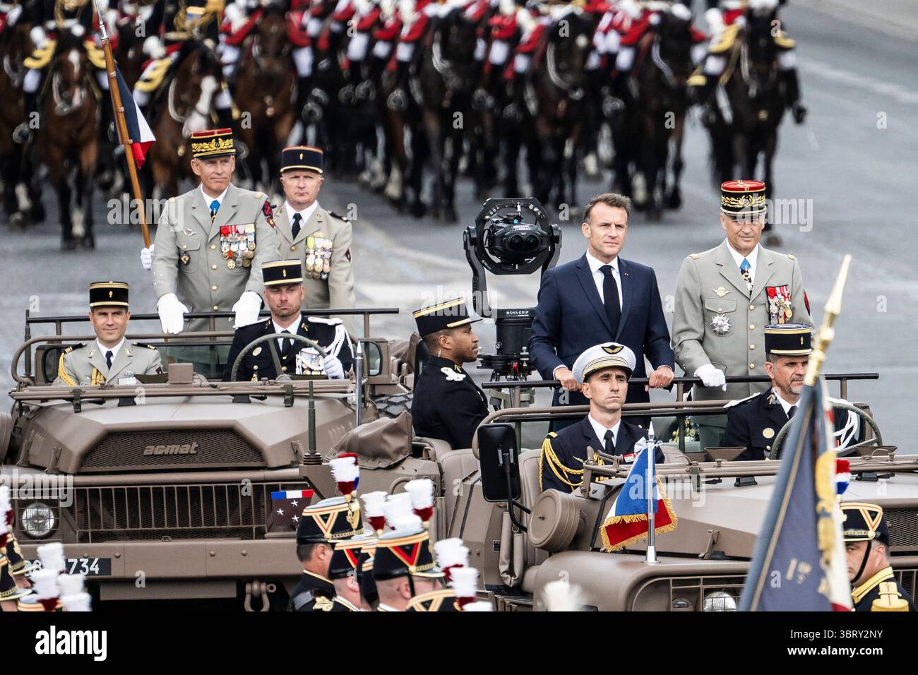French President Emmanuel Macron stands in the command car with Chief ...