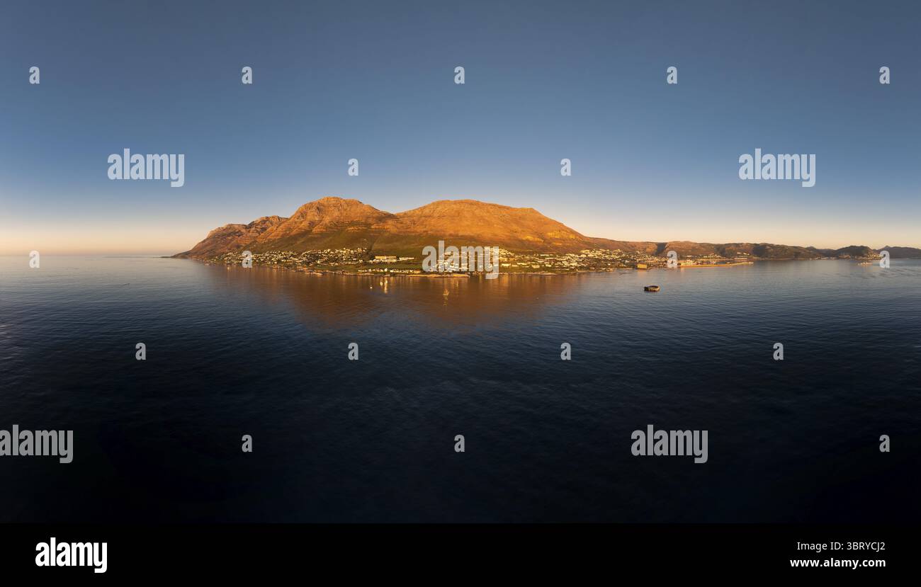 Aerial view of golden light kissing the rugged peaks and tranquil ...