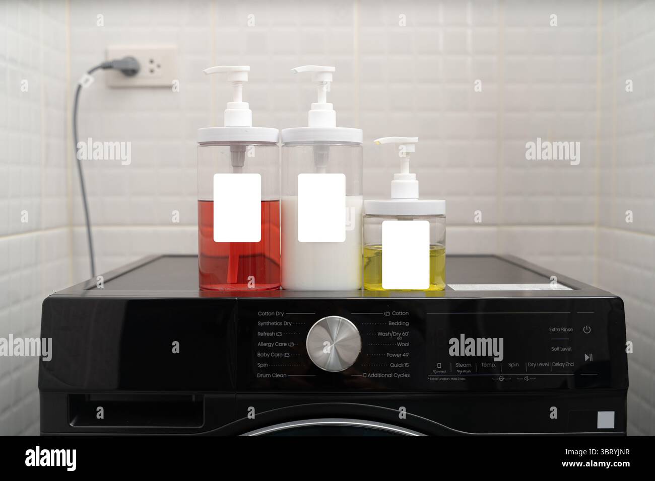 Three colorful liquid detergent bottles with pump placed on washing ...