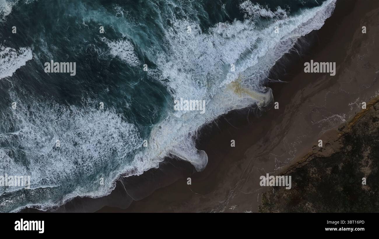 Aerial view of the dramatic meeting of dark, churning ocean waves and ...