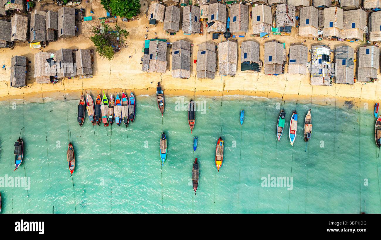 A stunning aerial view of a tropical beach village with rows of small ...