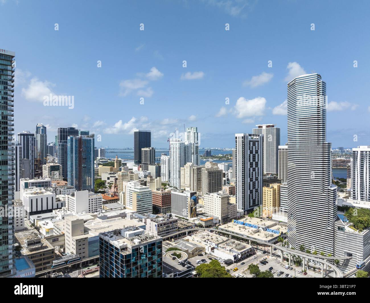 Aerial view of gleaming skyscrapers pierce the bright blue sky over the ...