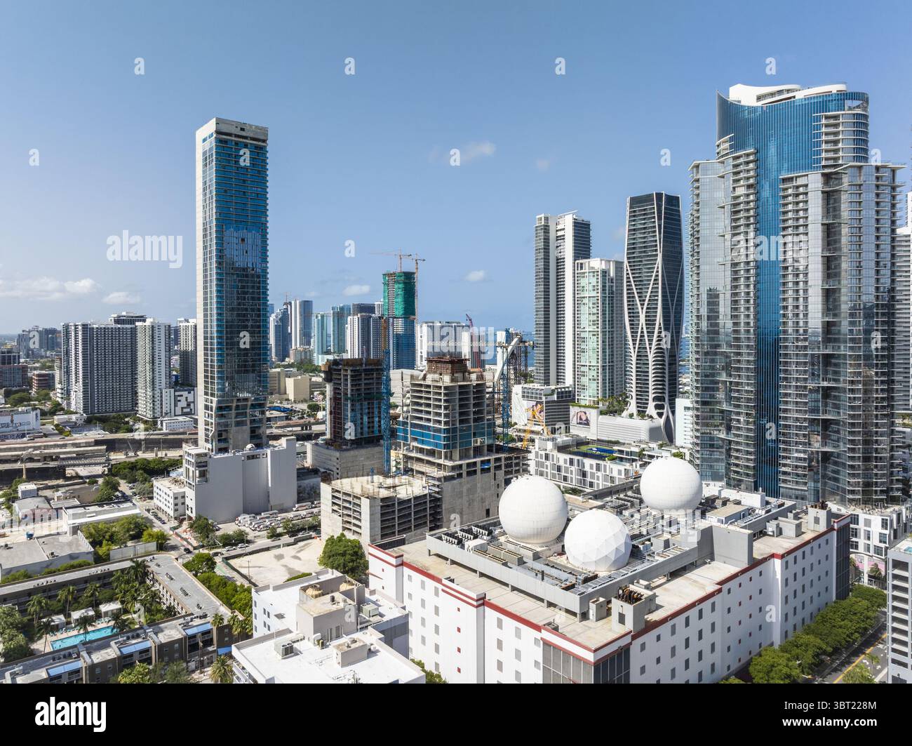Aerial view of gleaming skyscrapers pierce the clear sky, reflecting ...