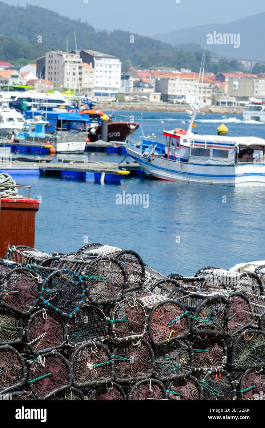 Traditional fishing traps are stacked on the dock with vibrant boats ...