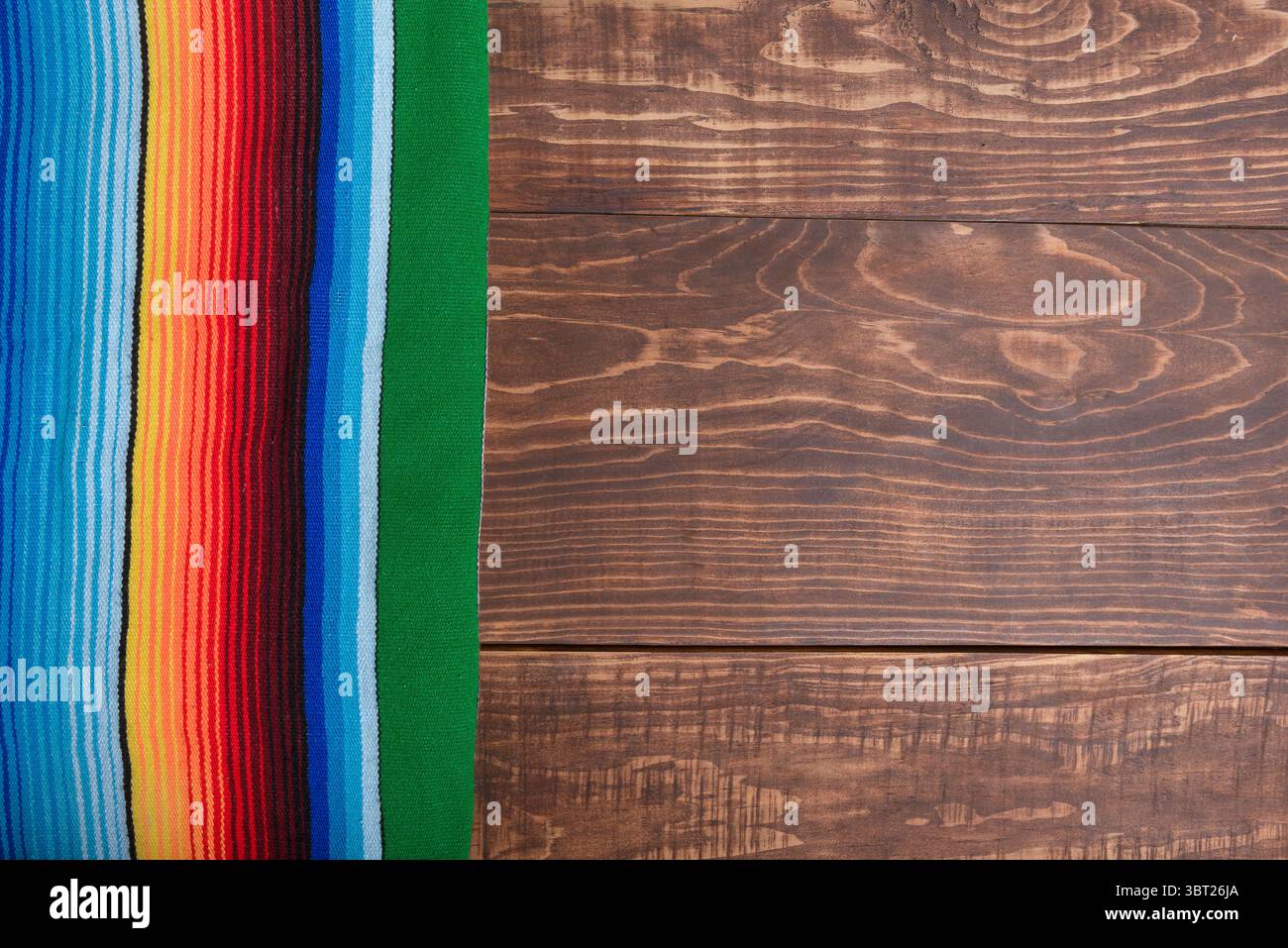 Colorful serape and maracas on wooden table. Typical colorful fabric ...