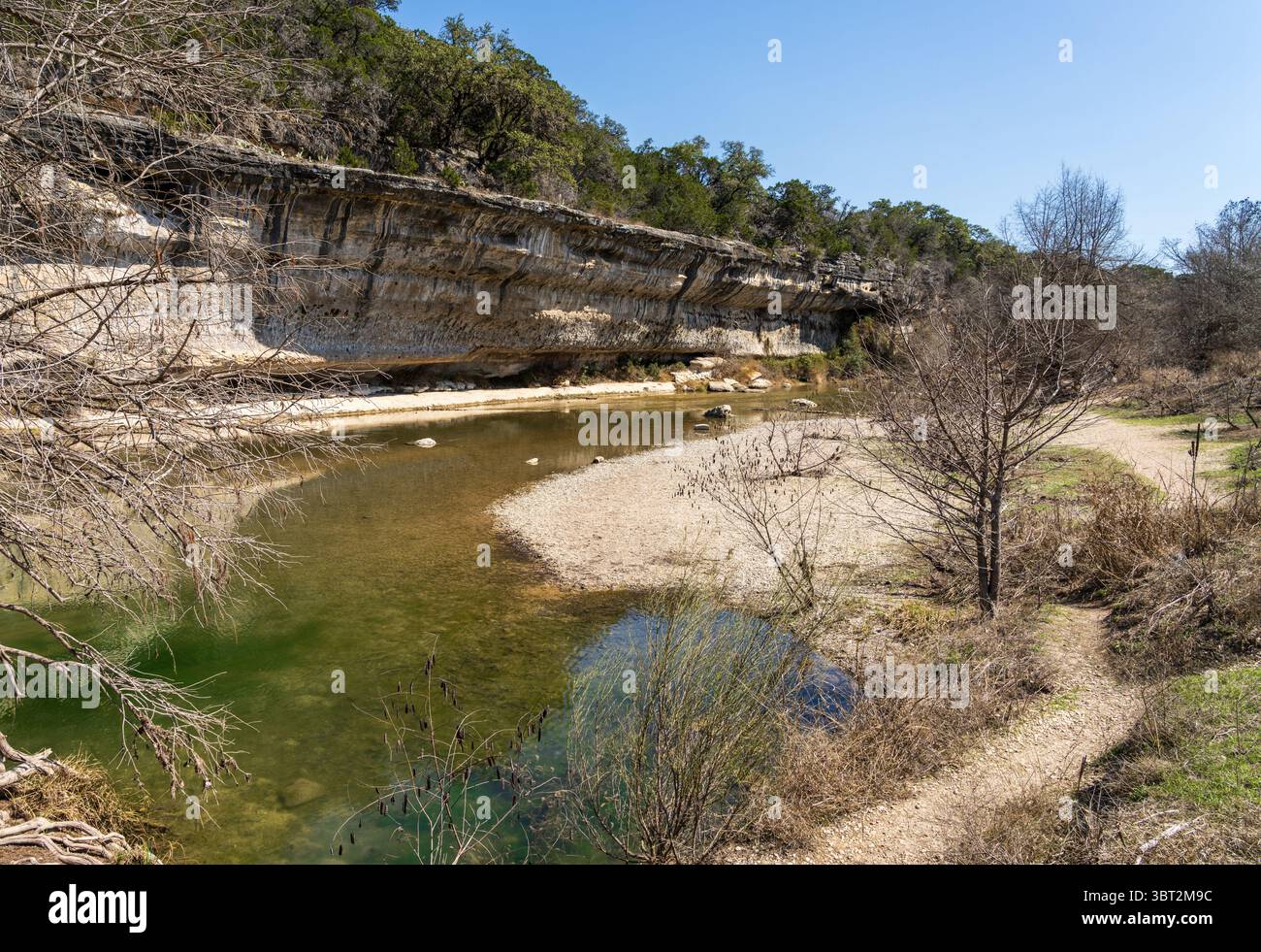 The Guadalupe River State Park with a limestone cliff along rocky beach ...