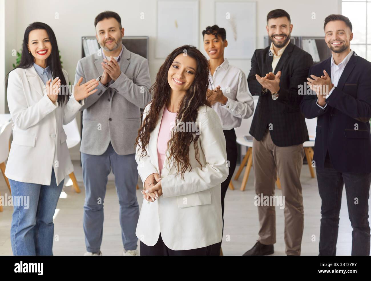 Group of young team members applauding, welcoming newcomer in company ...
