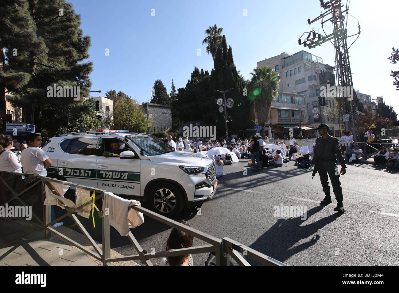 A police car drives by as silent protestors from the new protest ...