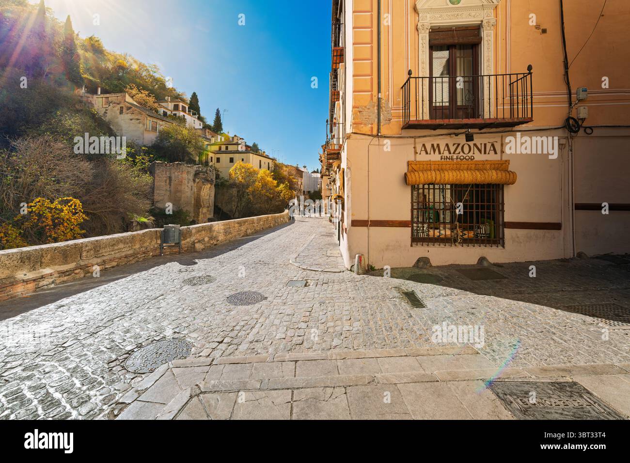 Pedestrians walk alongside the Darro river on the narrow, historic ...