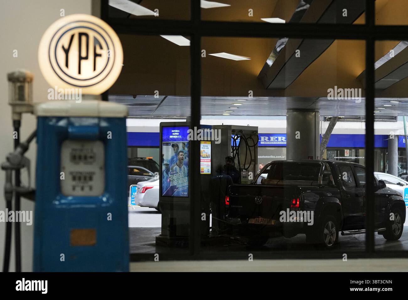 A worker fuels up a van at a YPF gas station in Buenos Aires, Argentina ...