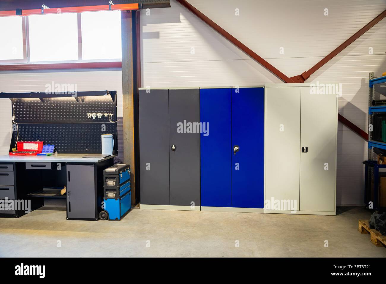 Metal cabinets and workbench with tools are arranged inside a spacious ...