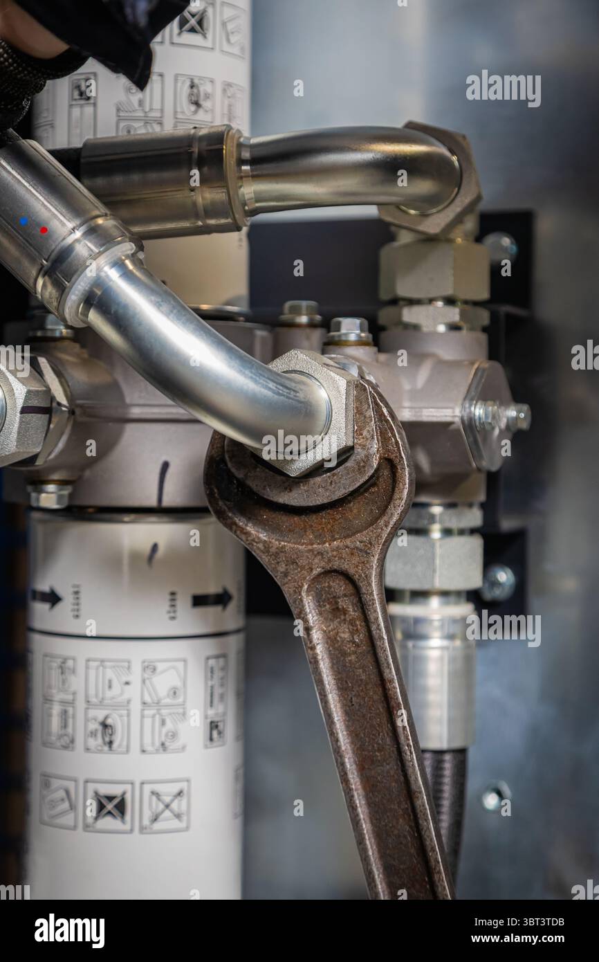 Close up of a wrench tightening a hydraulic pipe connection during ...