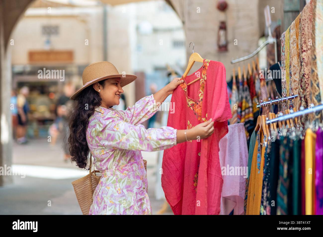 tourist Woman buying Dresses at Al Seef Heritage Market, local shopping ...