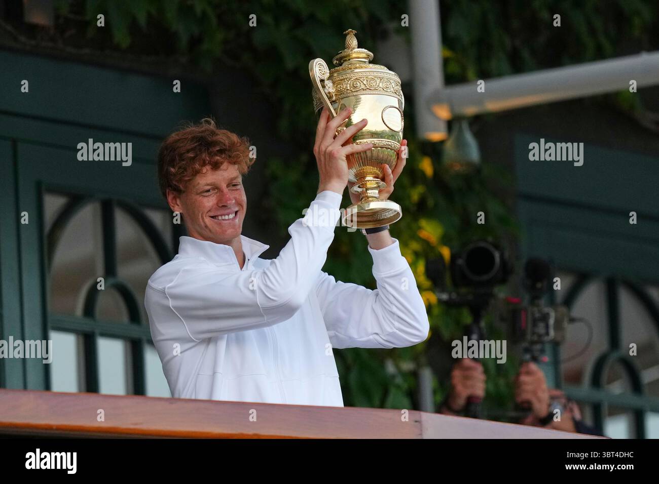 Italy's Jannik Sinner shows the trophy from the balcony of Centre Court ...