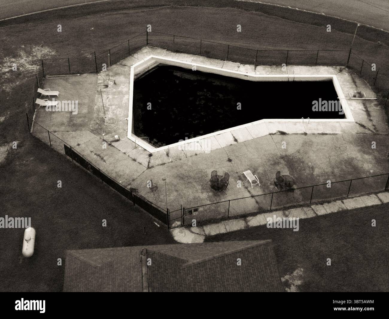 An old pool that has seen better days, makes an interesting black and ...