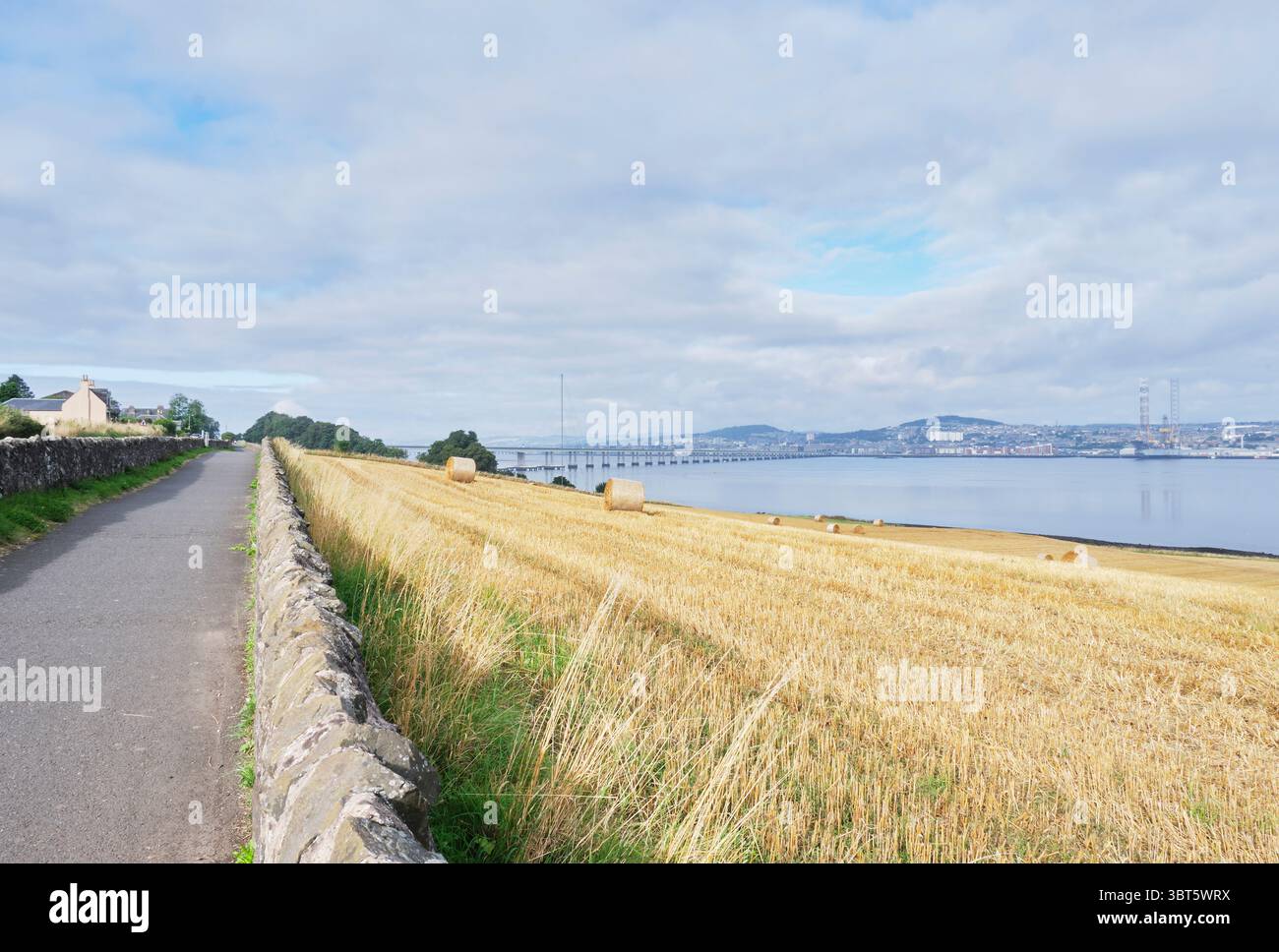 The Fife Coastal Path heading west beside a field with bales of hay ...