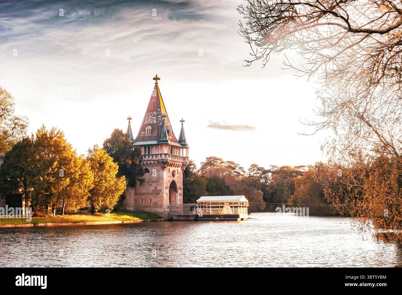 Medieval Franzensburg castle and small ferry on lake in autumn ...