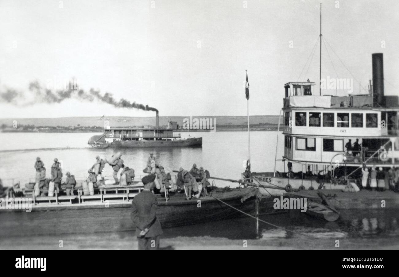 British soldiers boarding a barge on the River Nile, alongside the ...