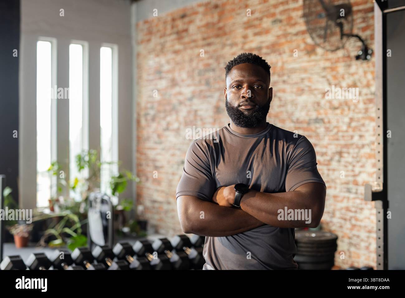 African American male fitness trainer wearing sportswear crossing arms ...