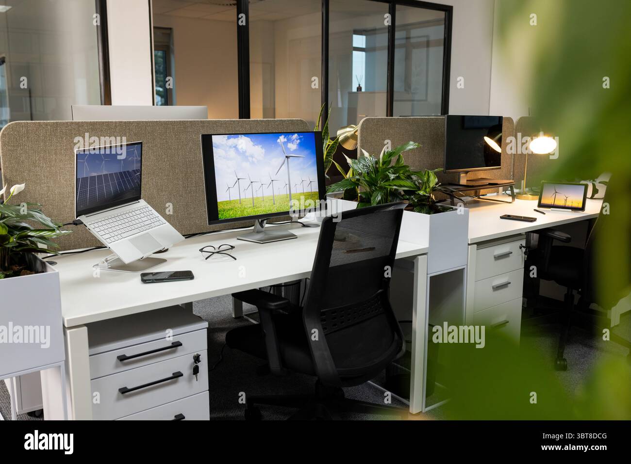 Workspace featuring monitors showing wind turbines, with devices, decor ...