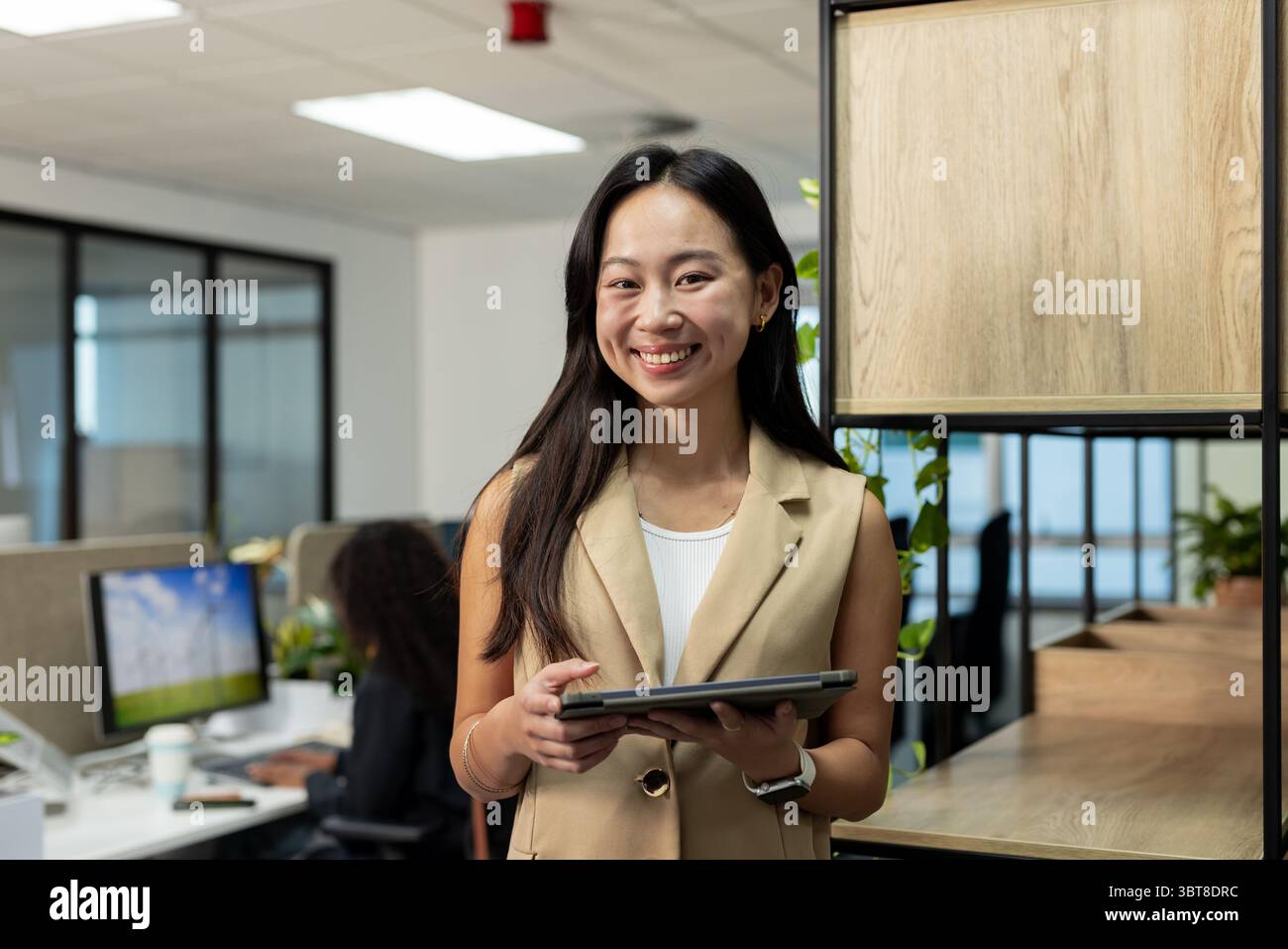 Diverse coworkers wearing business attire holding tablet and typing on ...
