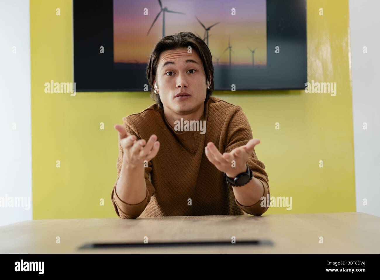 Asian man raising hands and explaining wind turbine display at ...