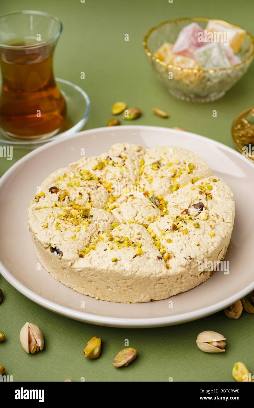 Plate of tasty Tahini halva with pistachios on green background Stock ...