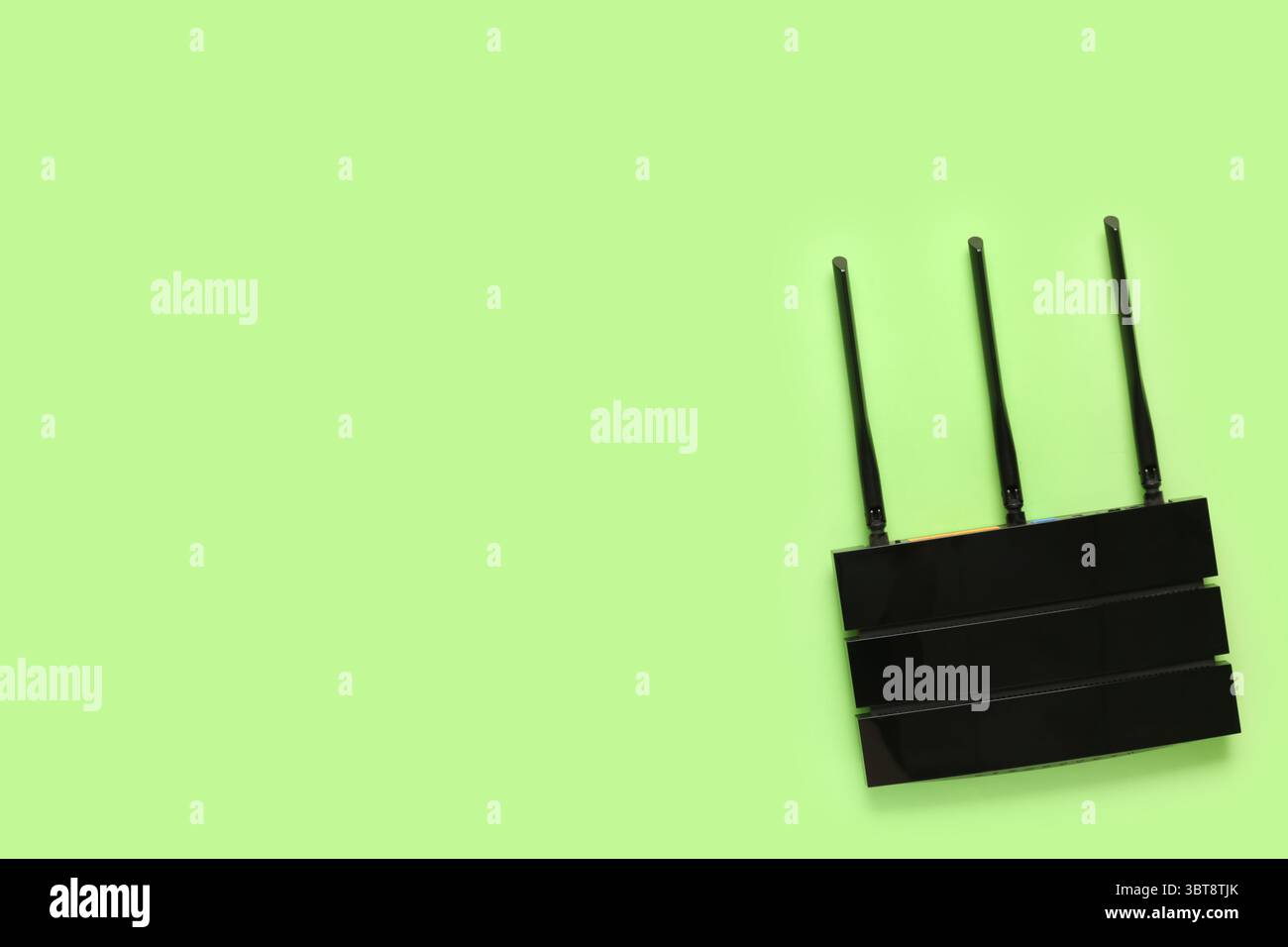Modern wi-fi router on green background Stock Photo - Alamy
