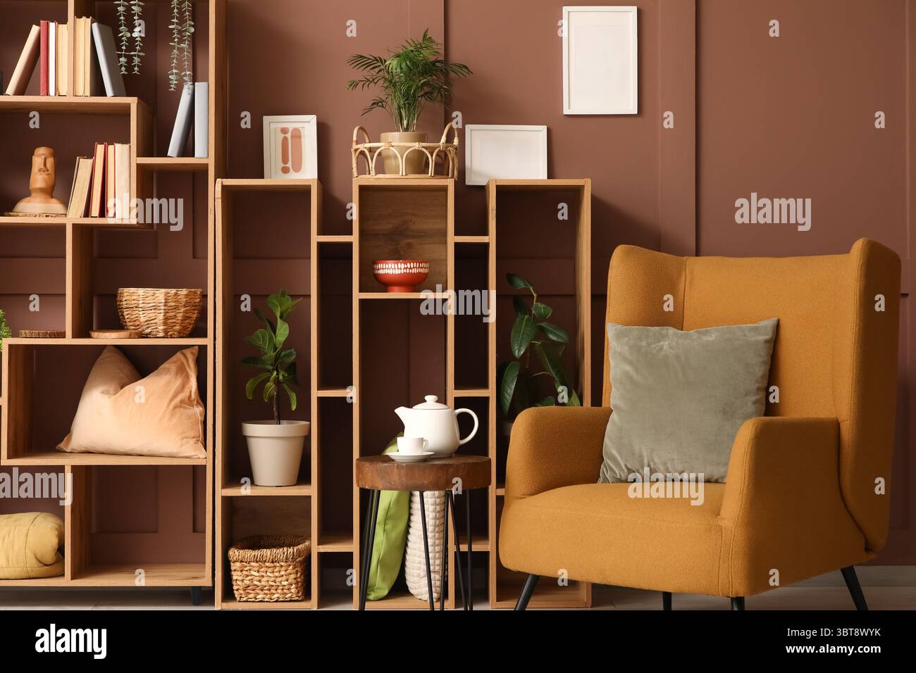 Interior of room with wooden shelf unit, plants and armchair Stock ...