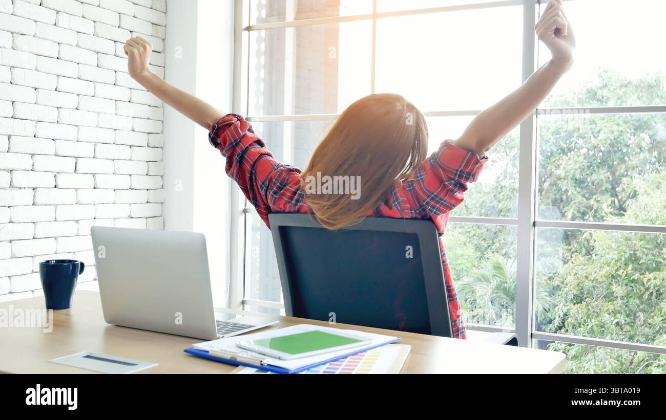 Woman streching arm raised sitting incorrect position home office desk ...