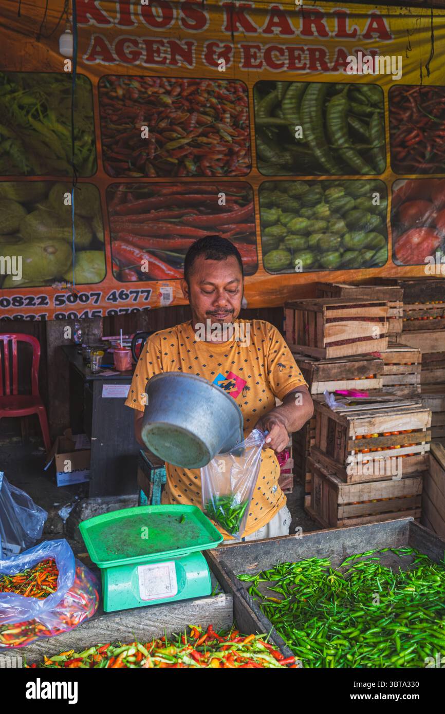 Balikpapan, Indonesia – April 19th 2025. A market vendor scoops green ...