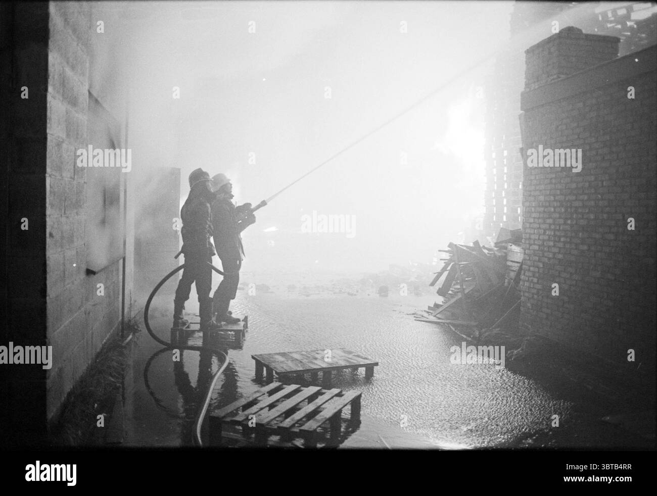 Two silhouettes firefighters stand in hi-res stock photography and ...