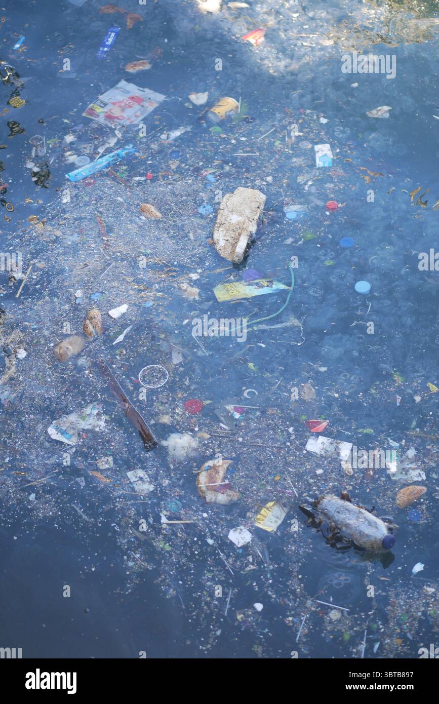 Polluted water is cluttered with trash in urban setting Stock Photo - Alamy