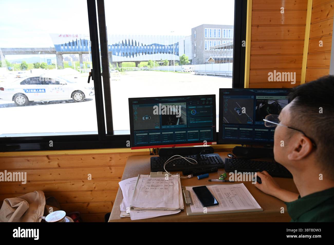 (250715) -- DONGYANG, July 15, 2025 (Xinhua) -- A coach monitors real-time status of AI-driven ...