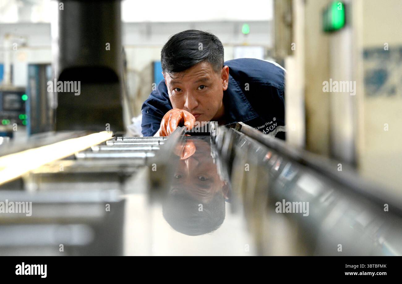 HANDAN, CHINA - JULY 15, 2025 - A worker is conducting guide rail ...