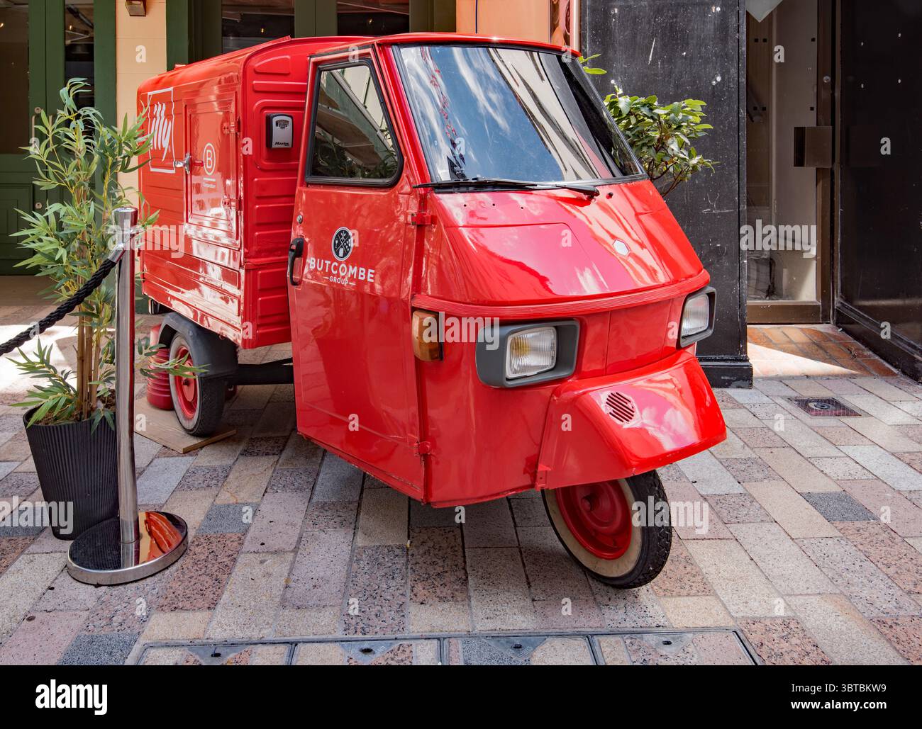 Glossy,bright red vehicle marked Butcombe group seen in the centre of ...