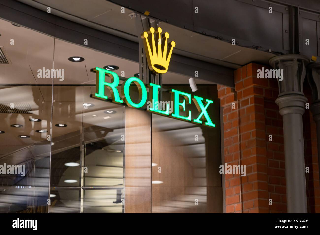 Poznan, Poland - June 30, 2025: The illuminated green Rolex sign with ...