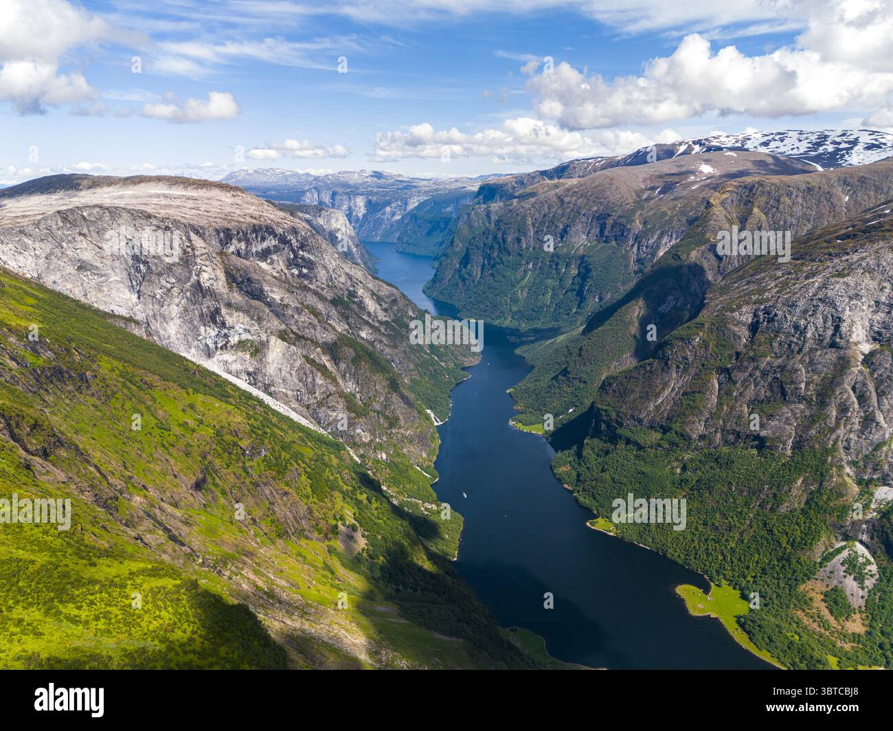 Aerial view of the deep blue waters carving through the rugged, green ...